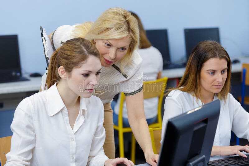 Teacher Guiding Teenage Lady Using Computers Stock Image - Image of ...