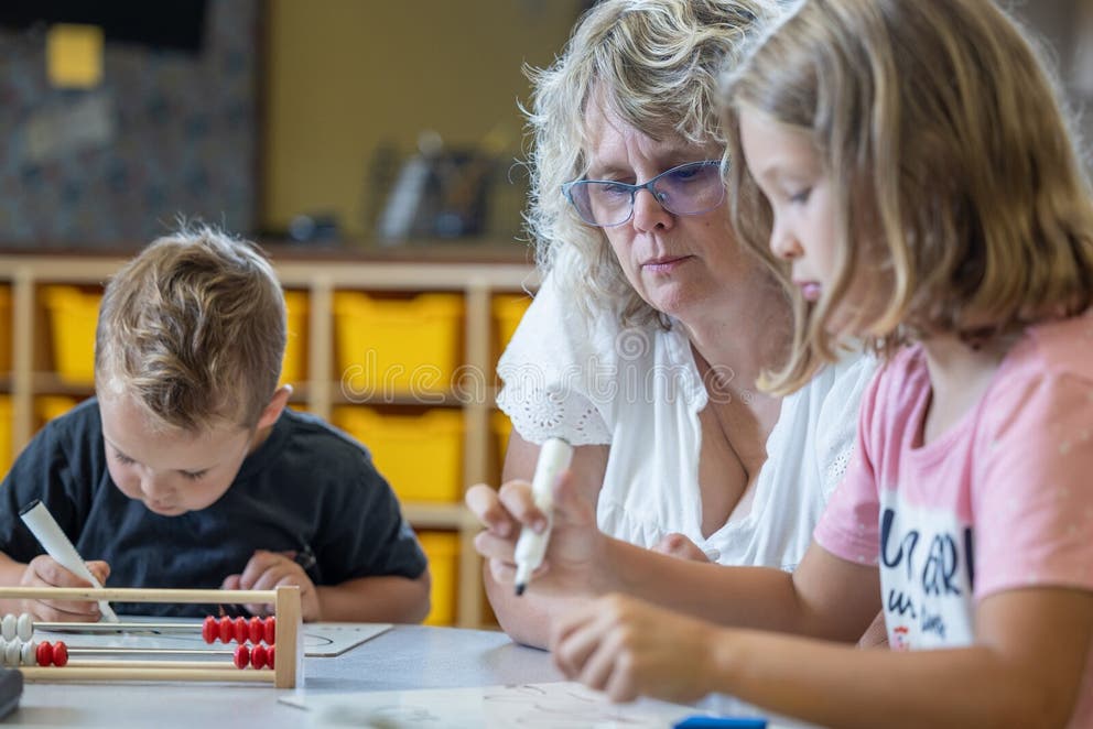 A Teacher is Helping a Child with a Math Problem Stock Image - Image of ...