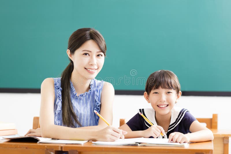 Young Teacher Helping Child with Writing Lesson Stock Photo - Image of ...