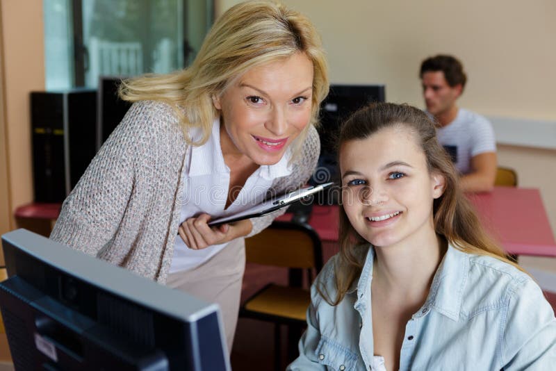 Teacher Helping College Student with Studies in Library Stock Photo ...