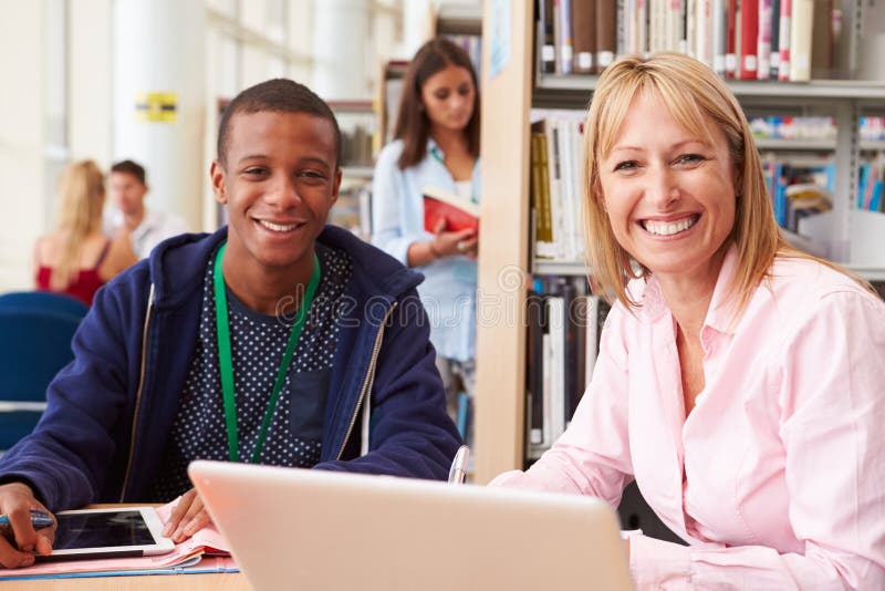Teacher Helping College Student with Studies in Library Stock Image ...