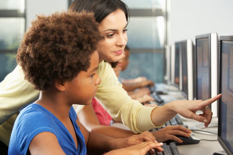 Teacher Helping Elementary Students Working At Computers Stock Photo ... Teacher Helping Elementary Students Working At Computers Stock Photo ...
