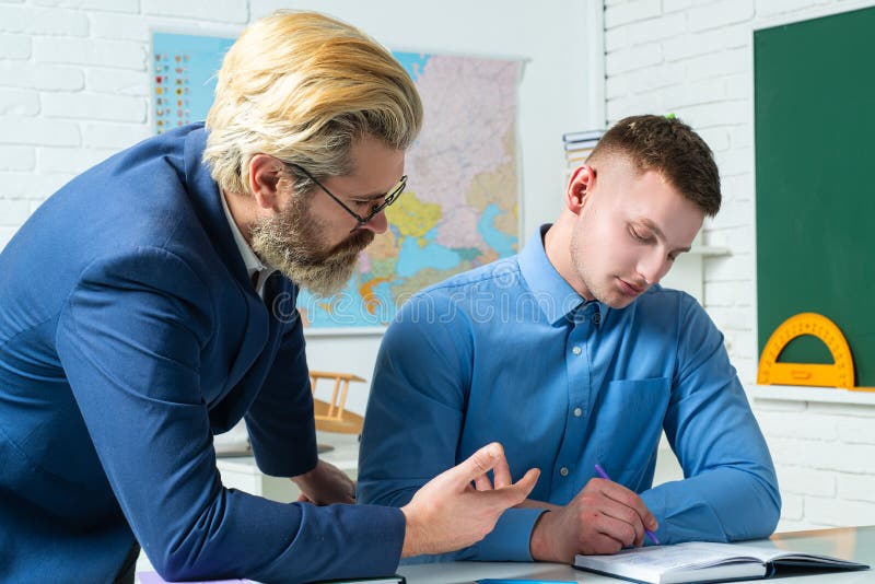 Teacher Helping High School Students. Student and Teacher on Exam in ...