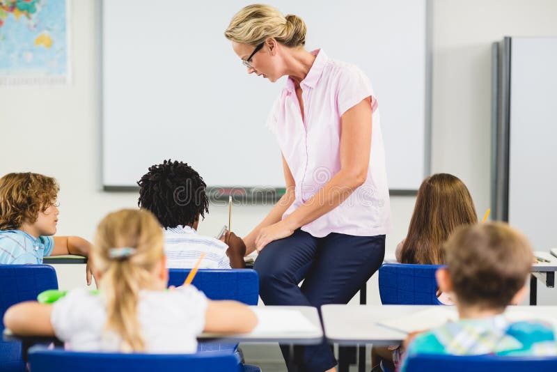 Teacher Helping Kids with Their Homework in Classroom Stock Photo ...
