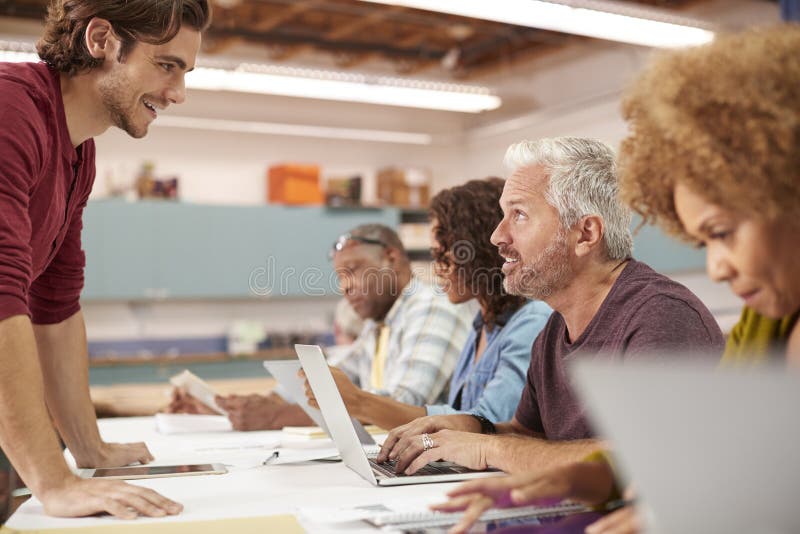 Teacher Helping Mature Man Attending it Class in Community Centre Stock ...