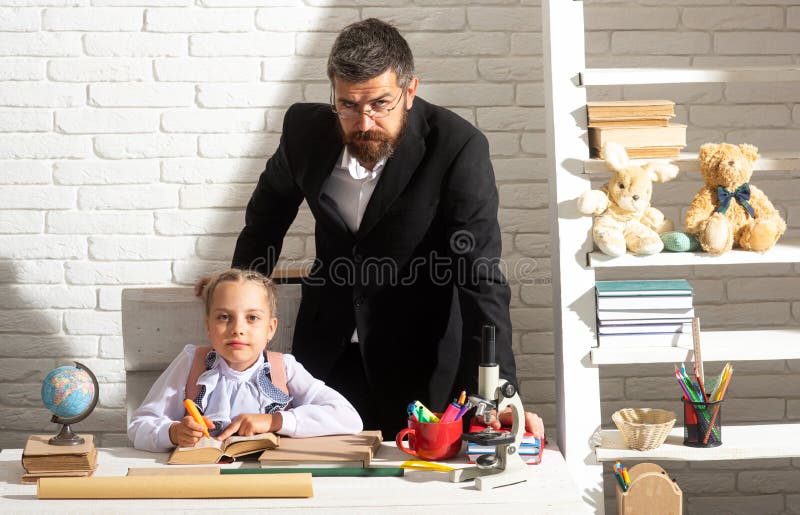 Teacher Helping Pupil Girl with Task in Classroom at School. Stock ...