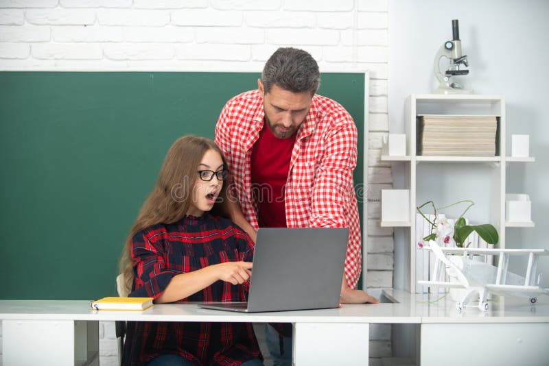Teacher Helping School Kids in Classroom at School, Using Computer ...