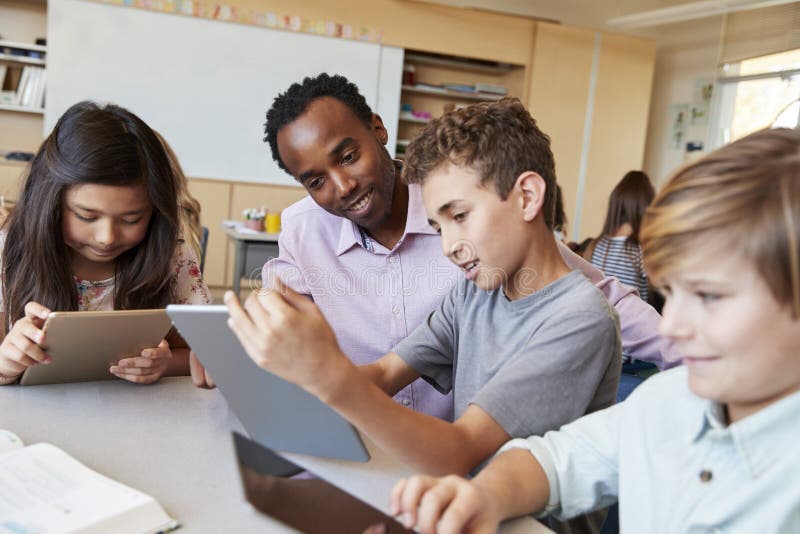 Teacher Helping School Kids Using Tablet Computers in Class Stock Image ...