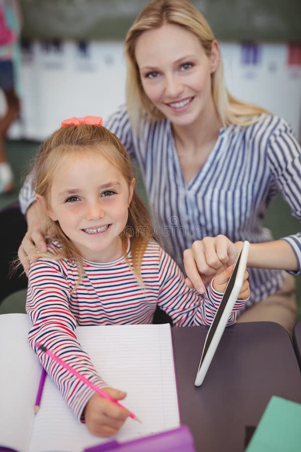Teacher Helping Schoolgirl with Her Homework in Classroom Stock Photo ...