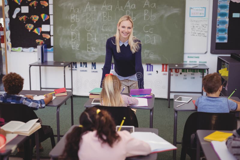 Teacher Helping Schoolkids with Their Homework in Classroom Stock Photo ...