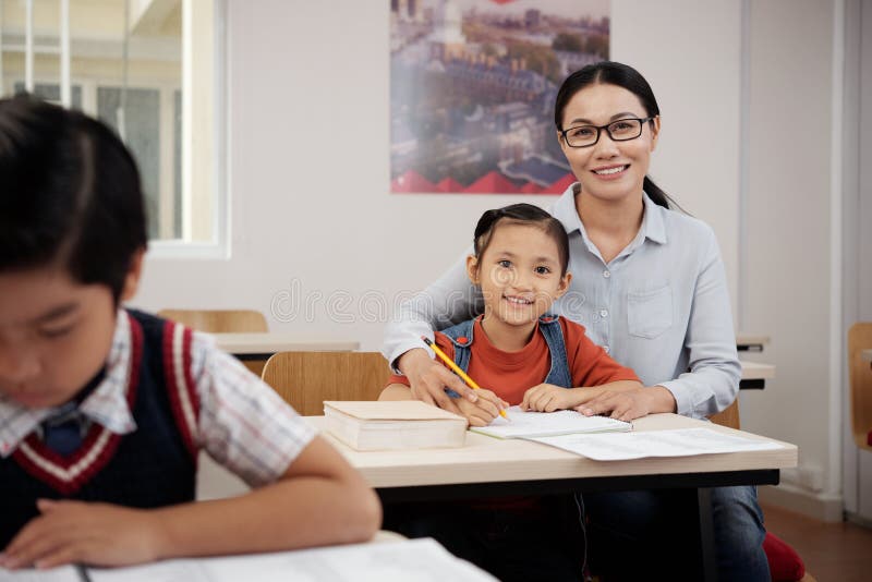 Teacher helping student stock photo. Image of school - 119980688