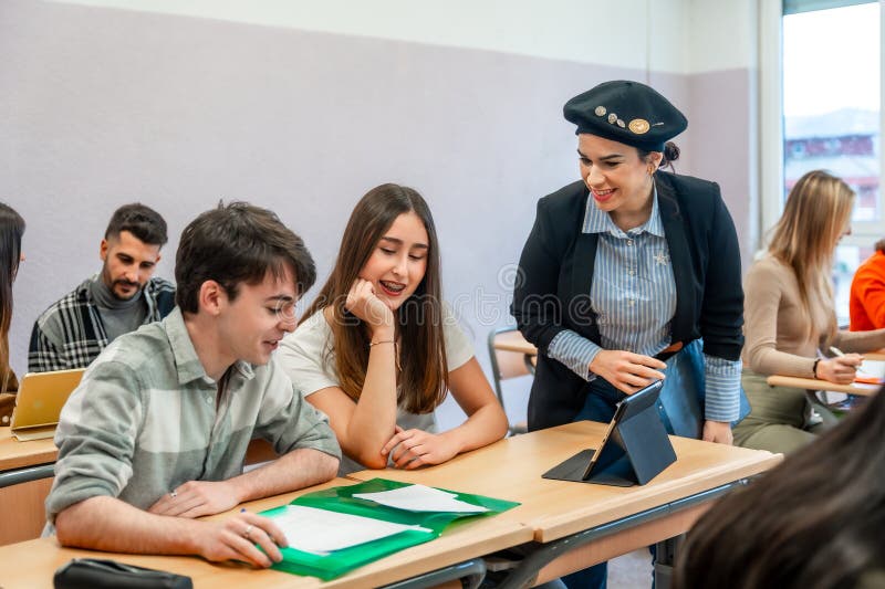 Teacher Helping University Students Studying Together in Classroom ...
