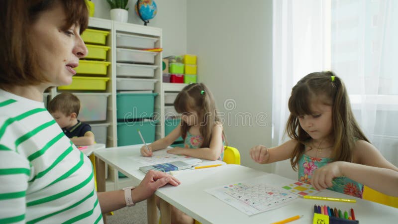The Teacher Helps the Girl and Explains How To Complete the Task in the ...
