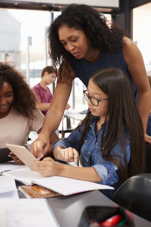 Teacher Helps High School Student with Technology, Vertical Stock Image ...