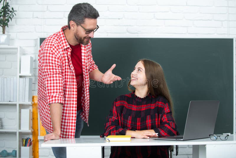 Teacher Helps School Kids To Learn Lesson. Stock Photo - Image of ...