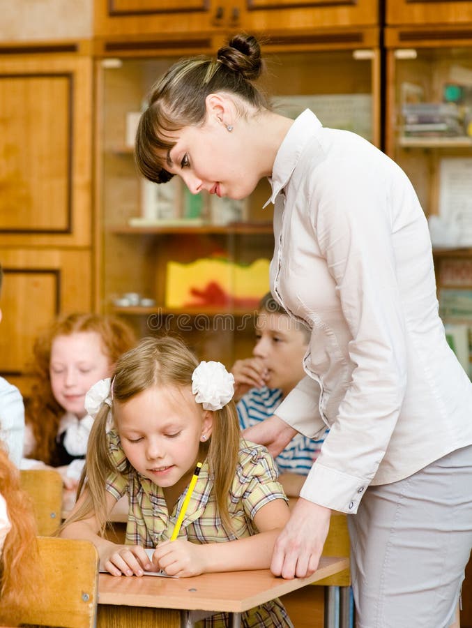Teacher Helps the Schoolkids with Schoolwork in Classroom Stock Image ...