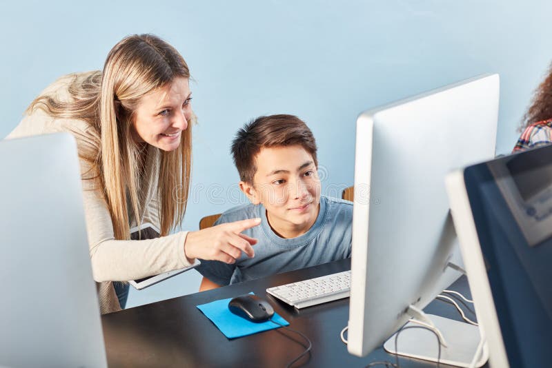 Teacher Helps a Student at the Computer Stock Photo - Image of kids ...