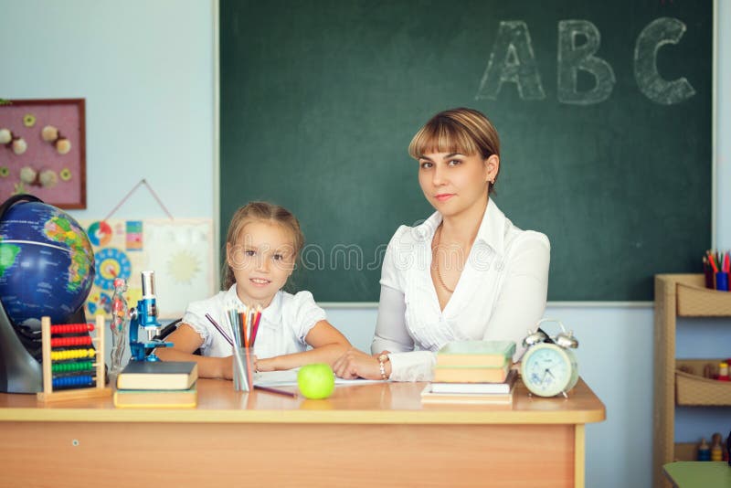 Cute Schoolgirl and Her Teacher in a Classroom Stock Photo - Image of ...