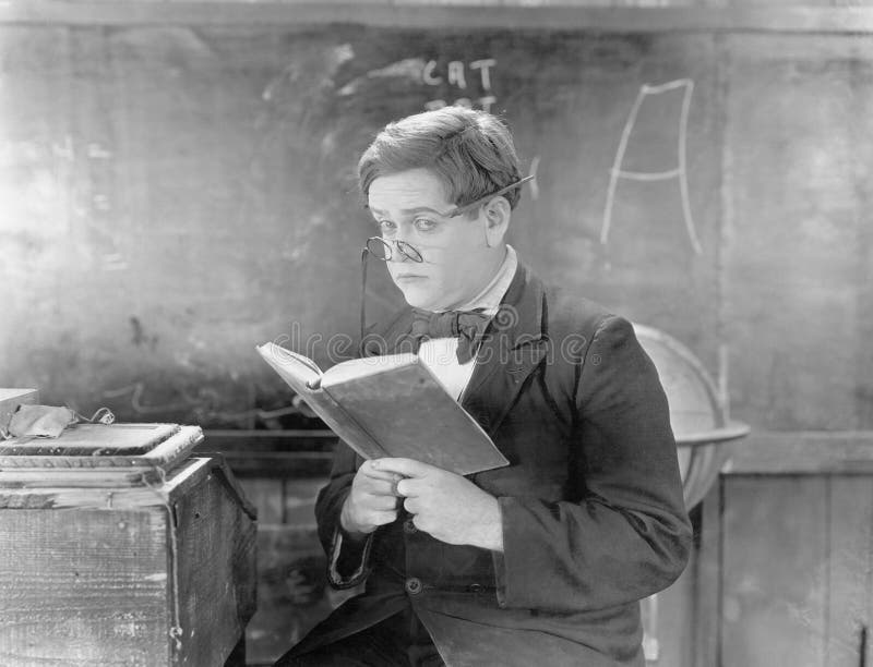 Teacher Holding a Book in Front of a Black Board Stock Image - Image of ...