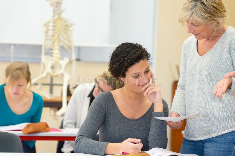 Teacher Holding Paper and Questioning Student in Anatomy Class Stock ...