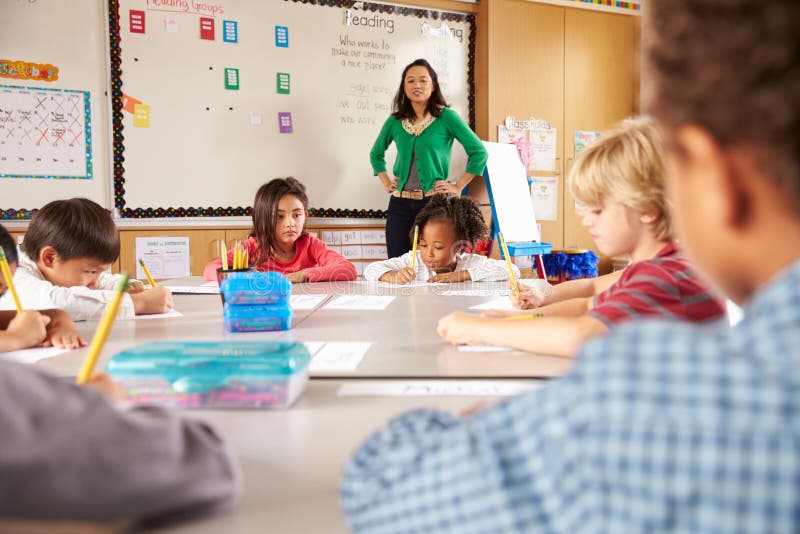 Teacher Instructing Elementary School Kids in Classroom Stock Image ...