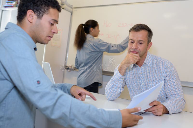 Teacher Interacting with Student Stock Photo - Image of papers ...