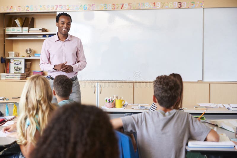 Teacher Working with Elementary School Kids at Their Desk Stock Image ...