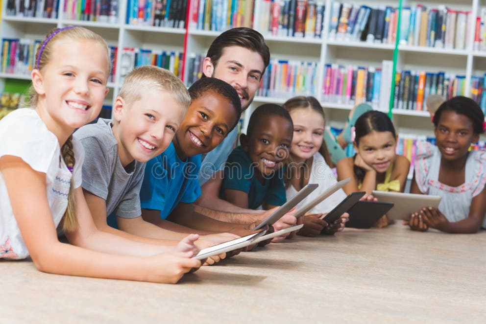 Teacher and Kids Lying on Floor Using Digital Tablet in Library Stock ...