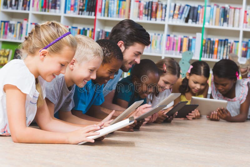 School Kids Sitting on Floor Using Digital Tablet in Library Stock ...
