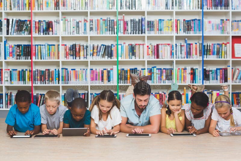 School Kids Sitting on Floor Using Digital Tablet in Library Stock ...