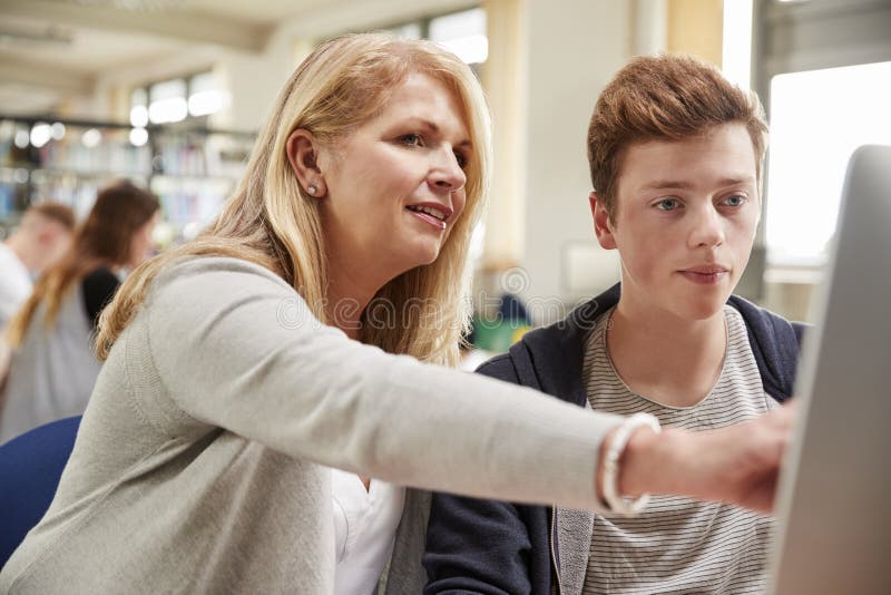 Teacher with Male Student Working on Computer in College Library Stock ...