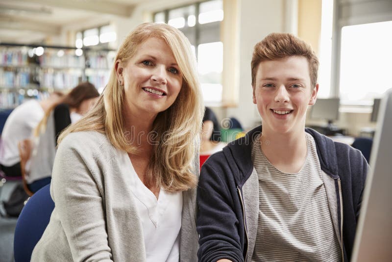 Teacher with Male Student Working on Computer in College Library Stock ...