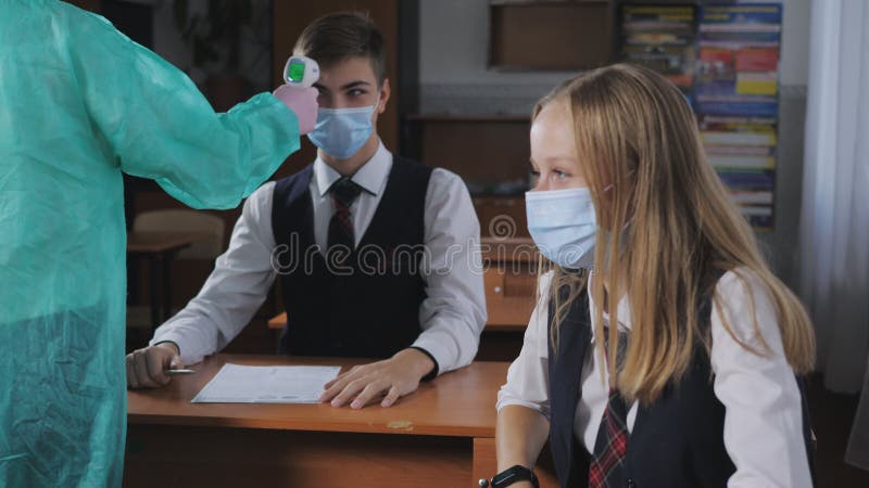 The Teacher Measures the Temperature with an Electronic Thermometer for ...