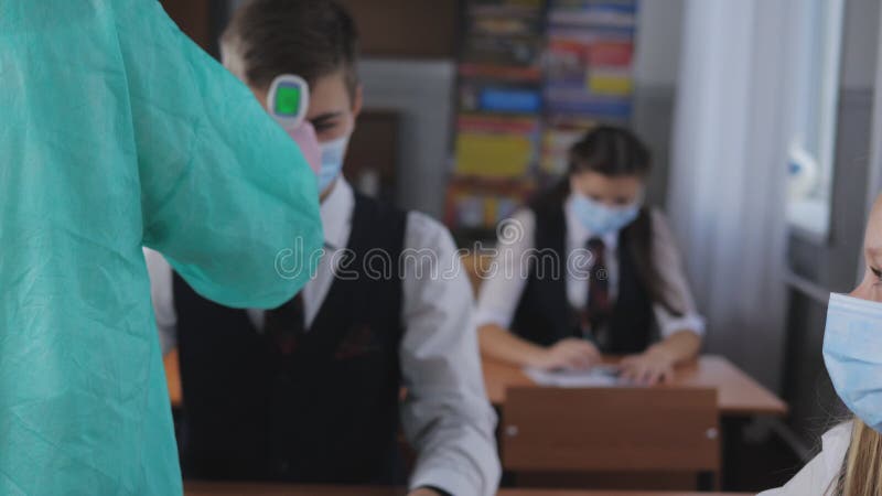 The Teacher Measures the Temperature with an Electronic Thermometer for ...