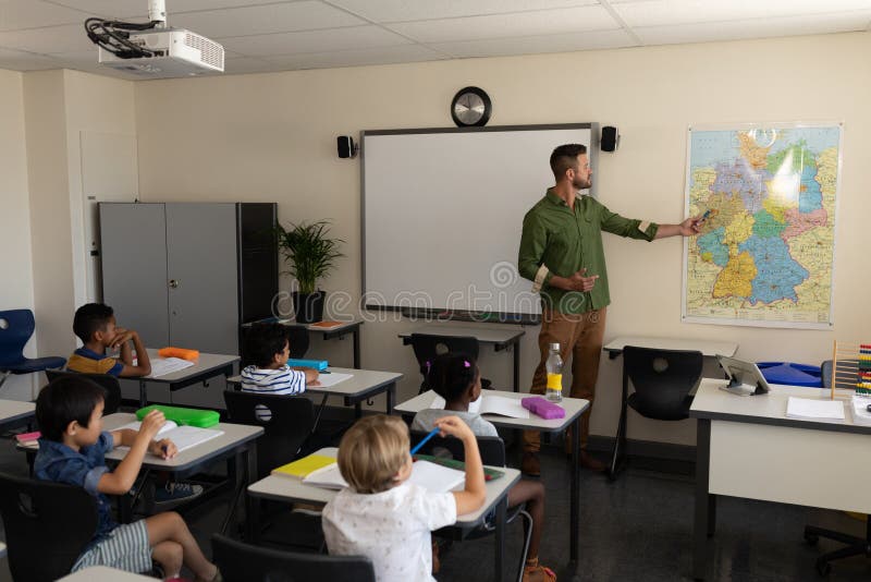 Teacher Pointing at a Map in Classroom Stock Image - Image of casual ...