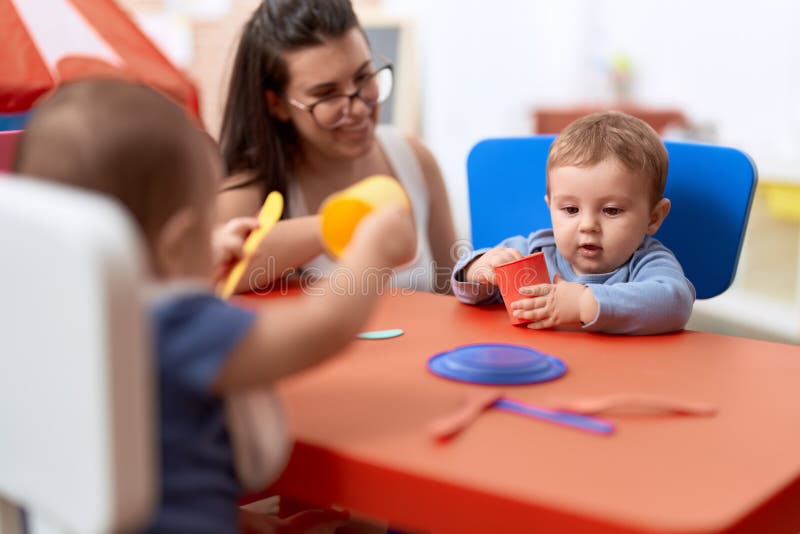 Teacher and Preschool Student Sitting on Table Learning To Eat at ...