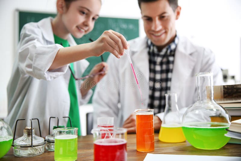 Teacher with Pupil Making Experiment at Table in Class, Focus on Hand ...