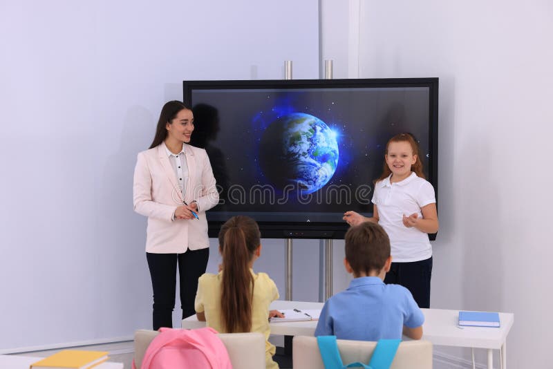 Teacher and Pupil Near Interactive Board in Classroom during Lesson ...
