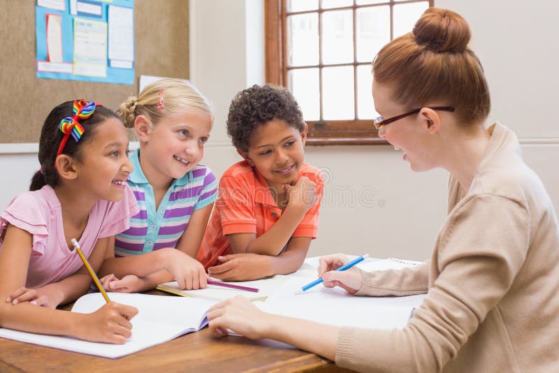Teacher Working with Elementary School Kids at Their Desk Stock Image ...