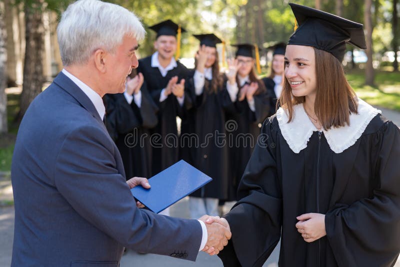 The Teacher Shakes Hands with the Student and Presents the Diploma ...