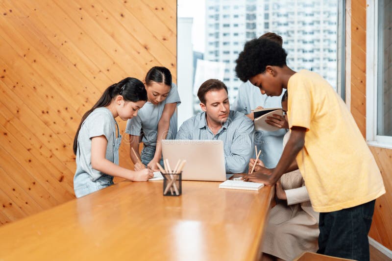Teacher Sitting and Giving a Lecture To Children Using Laptop ...