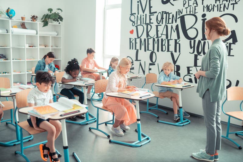 Teacher Standing in Front of Class Explaining New Topic. Stock Image ...