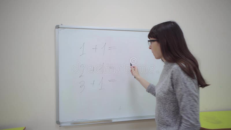 Teacher Stands at Whiteboard and Explains Rules of Addition in ...