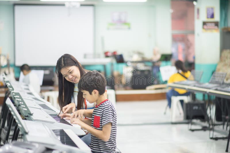 Teacher Teach Keyboard Electone Instument To a Boy in the Class Room ...