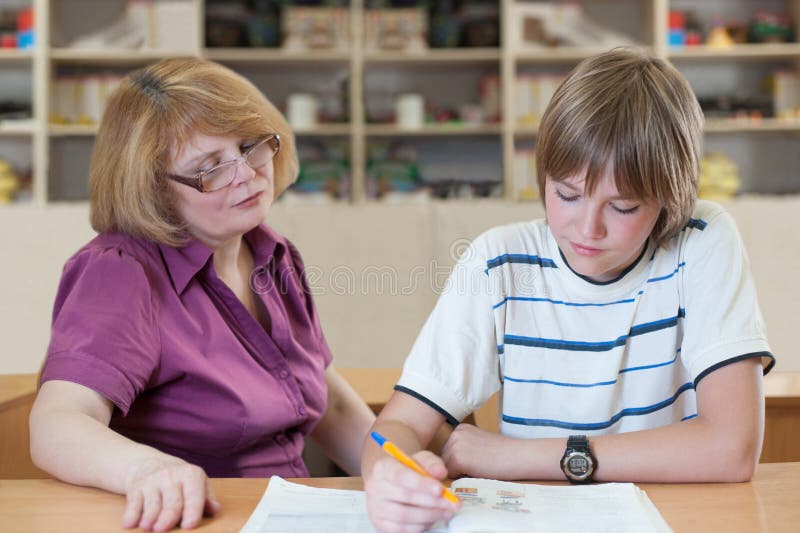 Teacher Teaches a Student at a Table in the Classroom Stock Image ...