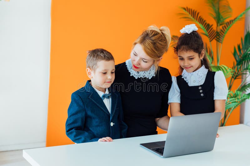 Teacher Teaching Boy and Girl on Computer at School Stock Image - Image ...