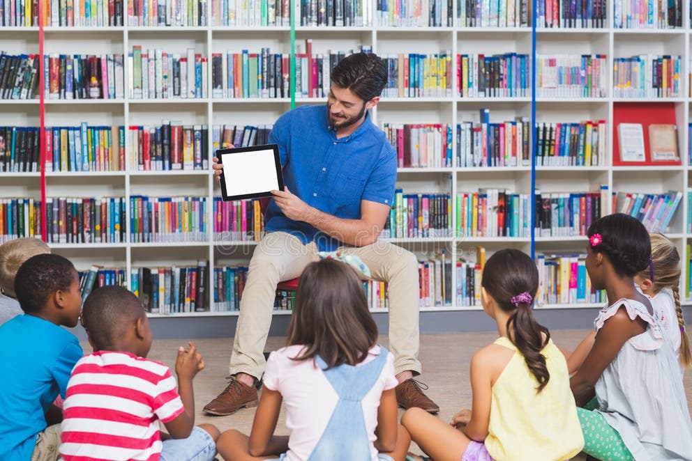 Teacher Teaching Kids on Digital Tablet in Library Stock Photo - Image ...