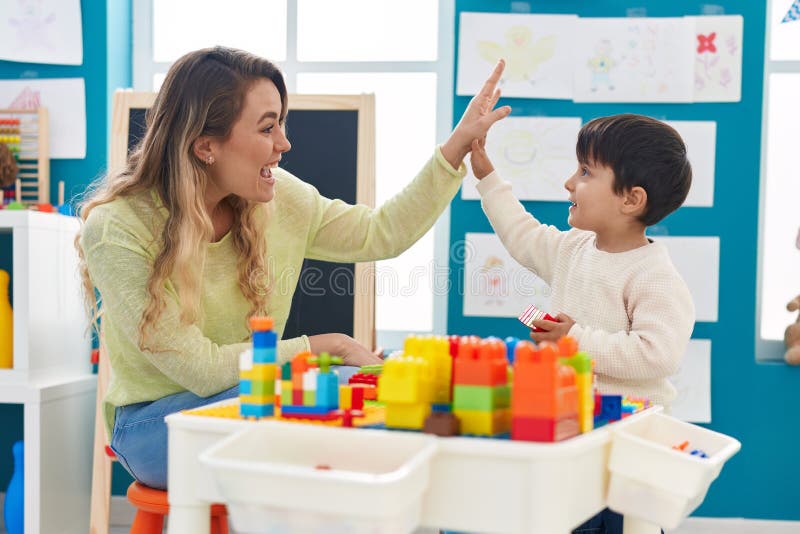 Teacher and Toddler Playing with Construction Blocks High Five at ...