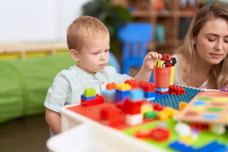 Teacher and Toddler Playing with Construction Blocks Sitting on Table ...