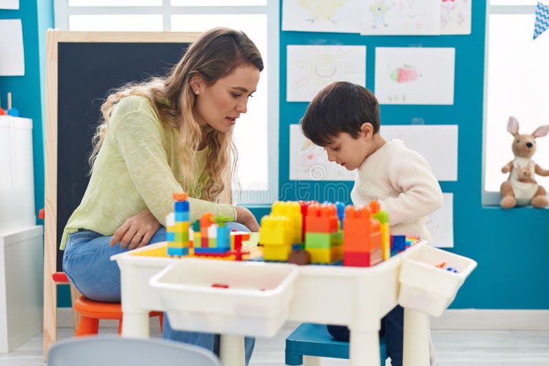 Teacher and Toddler Playing with Construction Blocks Sitting on Table ...